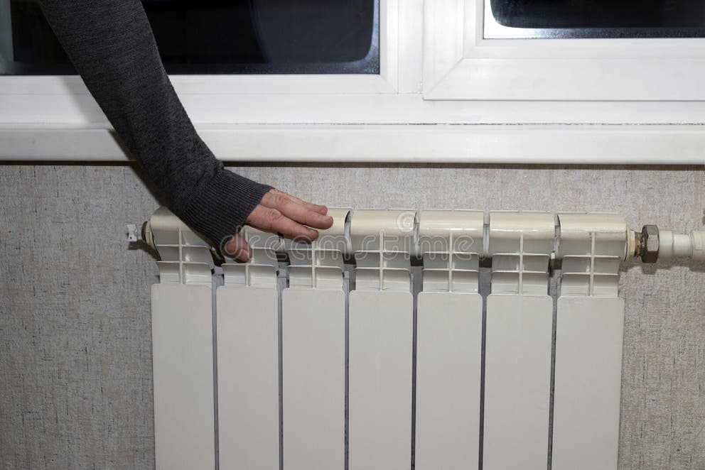 The Hand of a Man in a Jacket Touches a Heating Radiator. Modern Home ...