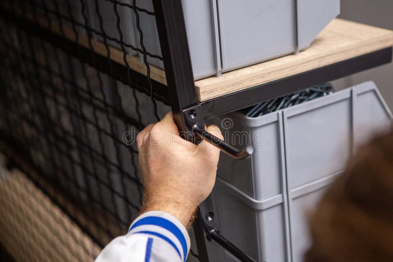 The Hand of the Man Lining the Shelf. he Mounts a Shelf in a Tool and ...