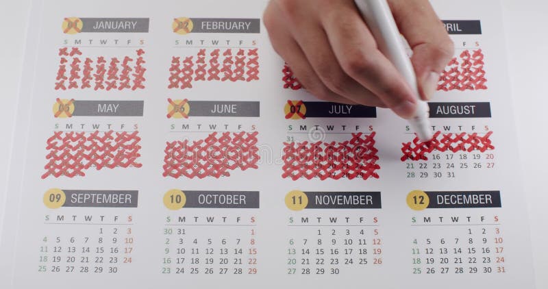Hand Marking Dates on Calendar with Red Crosses for August Month Stock ...