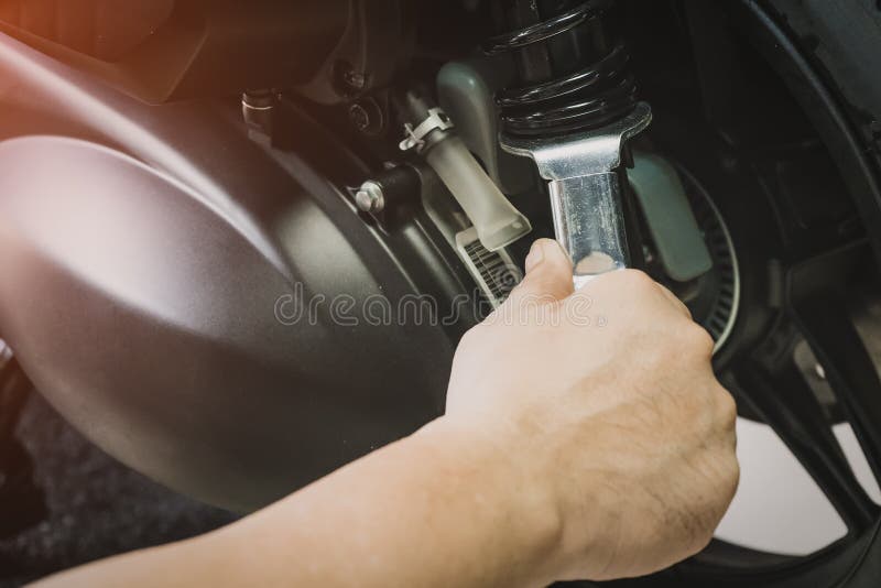 Hand of Mechanic Using a Wrench and Socket Adjust Shock Absorber ...