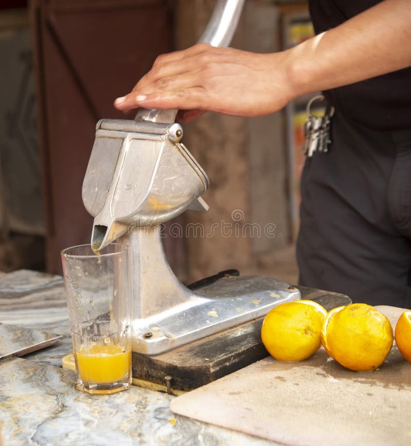 Hand of Men is Squeezing Orange Fruit Using Manual Hand Press Juicer ...