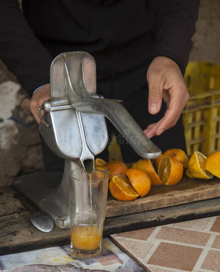 Hand of Men is Squeezing Orange Fruit Using Manual Hand Press Juicer ...