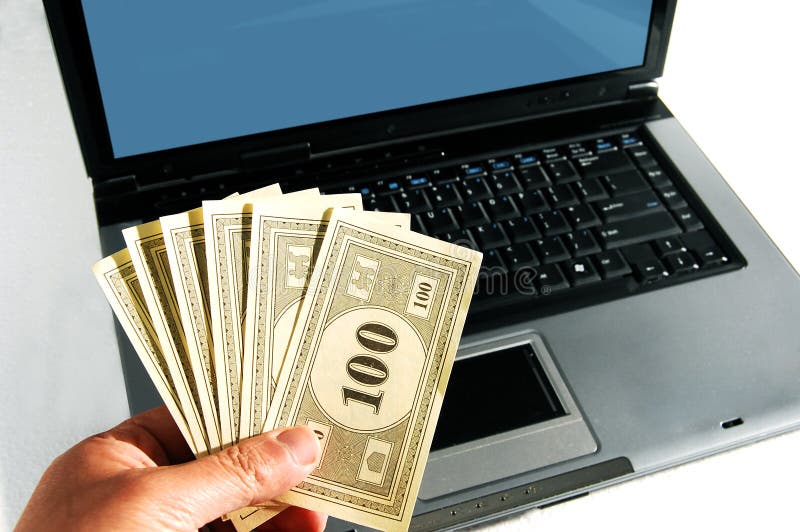 A Hand with Money in Front of a Computer Stock Photo - Image of hand ...