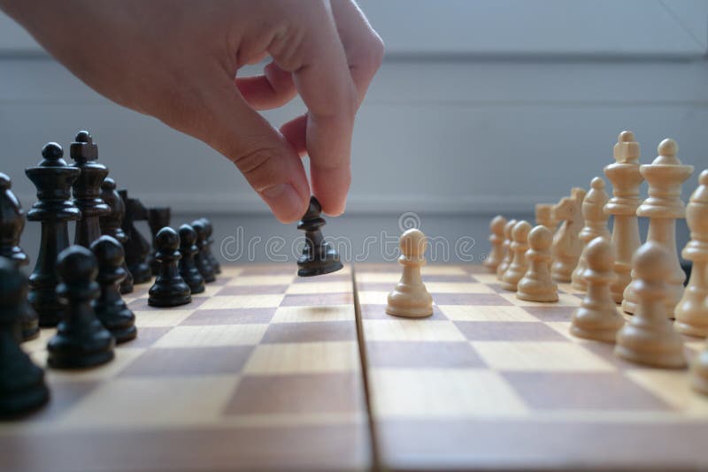 A Hand is Moving a Black Pawn, after the White Side Started the Game ...