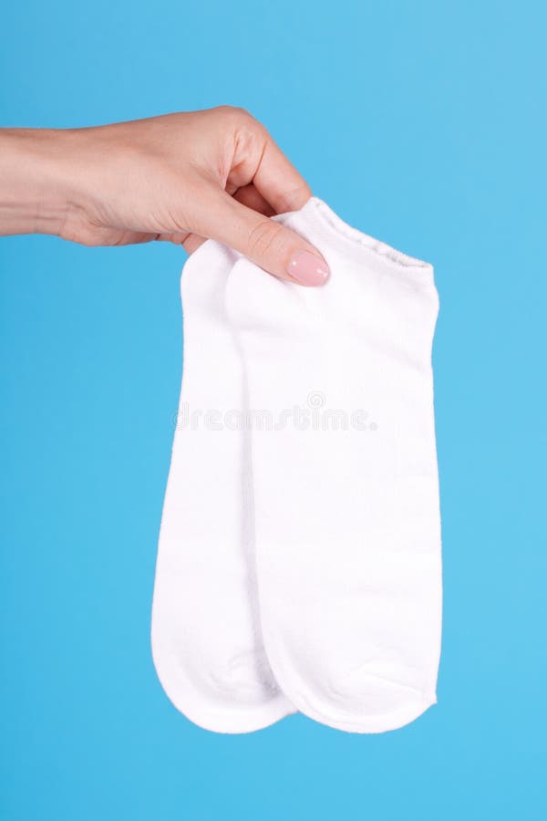 Hand with New White Cotton Socks. Isolated on Blue Background Stock ...