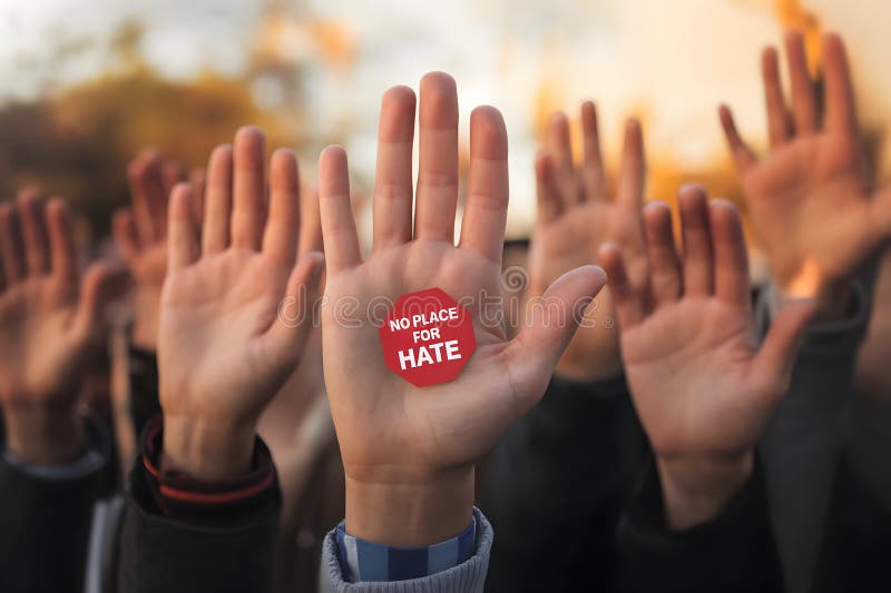Hand with NO PLACE for HATE Sticker Amidst Gathering, Symbolizing Unity ...