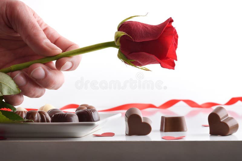 Hand Offering a Rose and Chocolates on White Table Isolated Stock Image ...