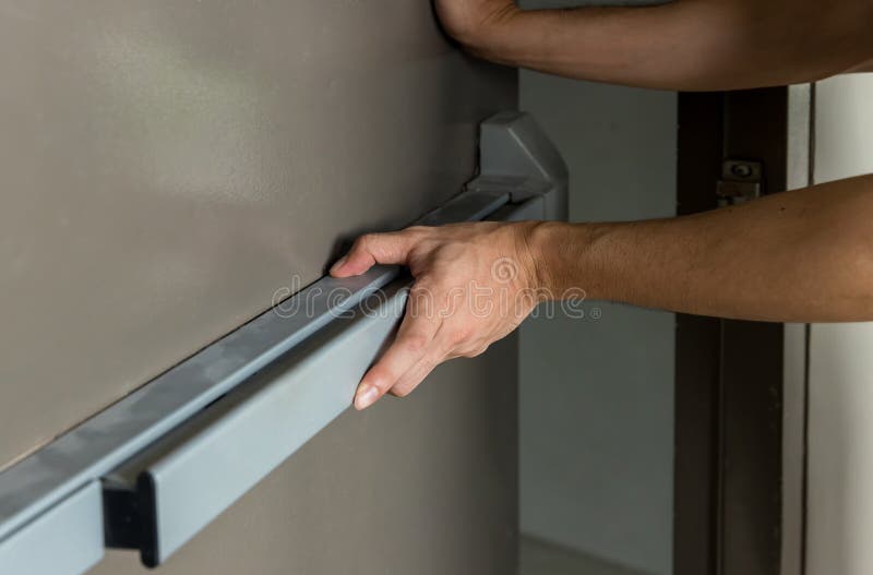 Hand is Opening the Emergency Fire Exit Door. Emergency Fire Exit Door ...