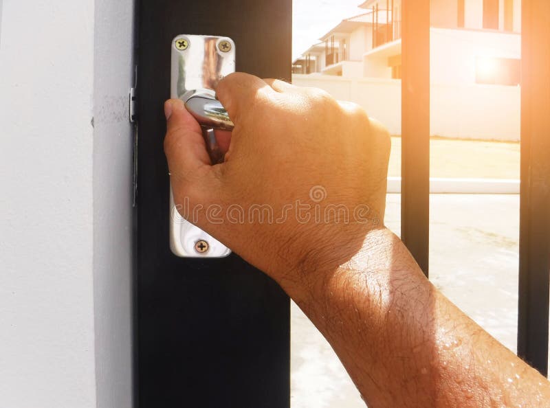 Hand is opening the gate. stock image. Image of metallic - 99488613