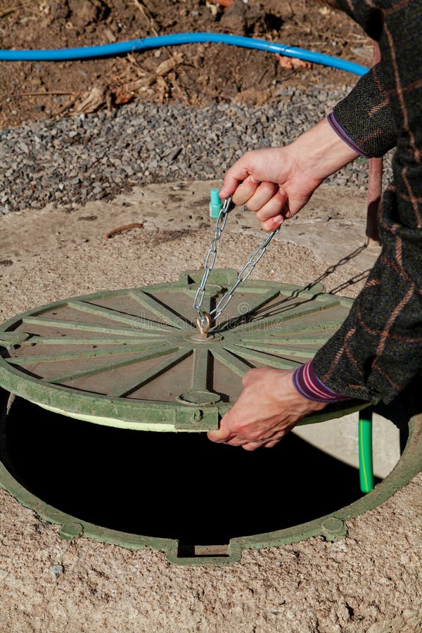 Hand Opens Sewer Hatch in Yard Stock Image - Image of device, outdoors ...