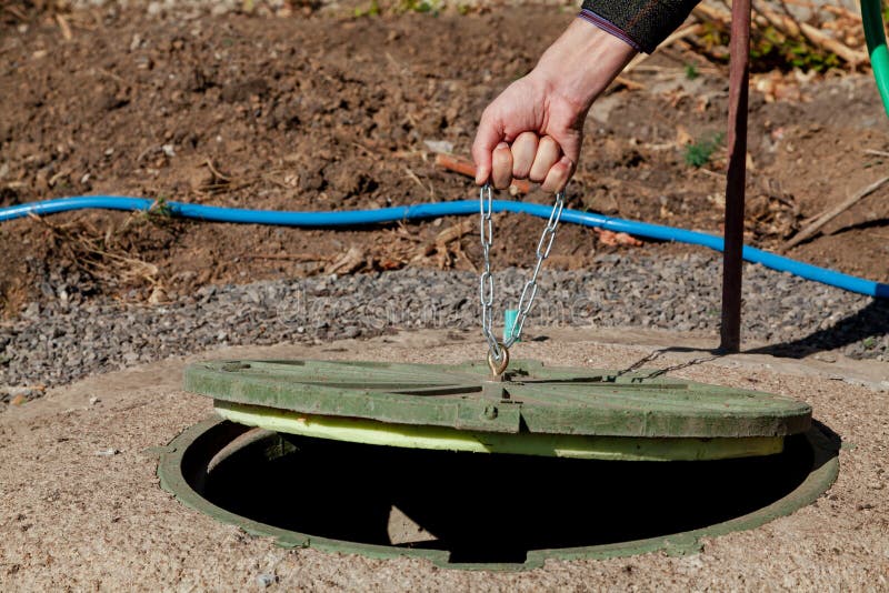Hand Opens Sewer Hatch in Yard Stock Photo - Image of access, bracket ...