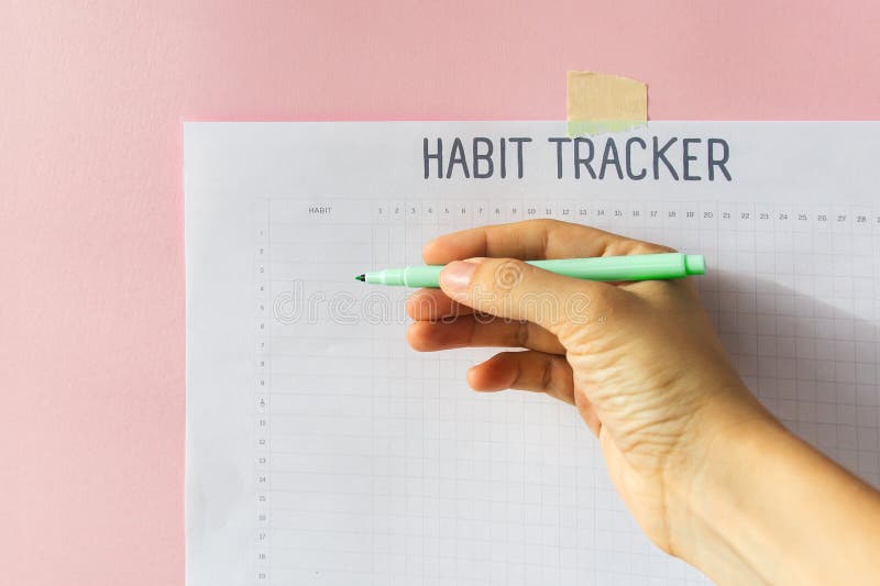 Hand with a Pen on the Background of a Habit Tracker Hanging on a Pink ...