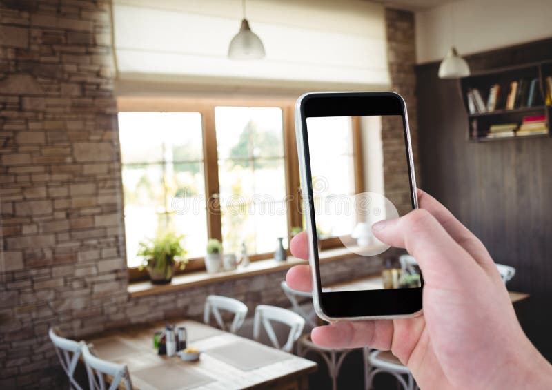 Hand of Person Taking a Picture of a Dinning Room with Her Smartphone ...