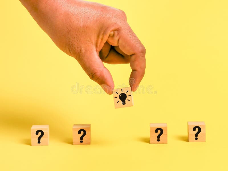 Hand Pick Wooden Cube with Light Bulb Sign among a Row of Question Mark ... Hand Pick Wooden Cube with Light Bulb Sign among a Row of Question Mark ...