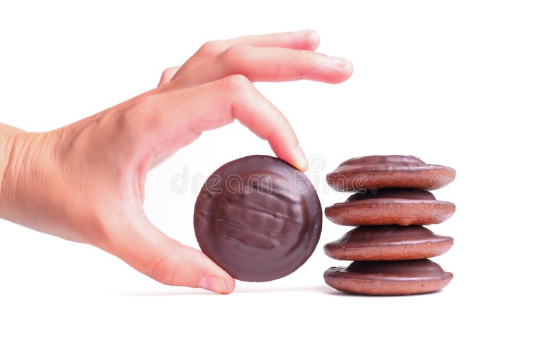 Hand Picking Chocolate Cookie Next To Stack on White Background Stock ...
