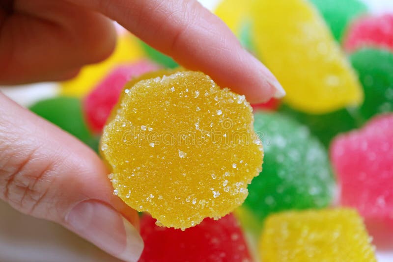 Hand Picking a Yellow Flower Shaped Soft Jelly Candy Stock Image ...