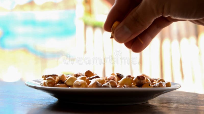 Hand Picking Nuts from Plate Against Blurred Background Stock Image ...
