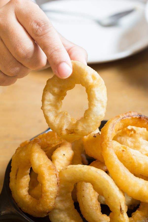 Hand Picking Onion Rings in Black Plate on the Wood Table in Restaurant ...