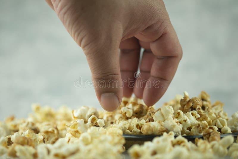 Hand Picking a Tasty Popcorn Stock Photo - Image of buttered, classic ...