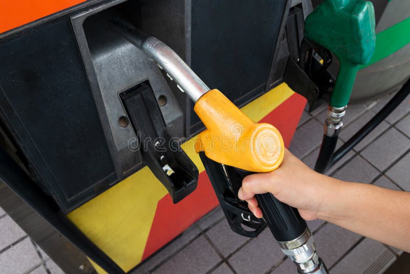 With the Hand that is Picking Up Fuel Dispenser at the Petrol Pump ...