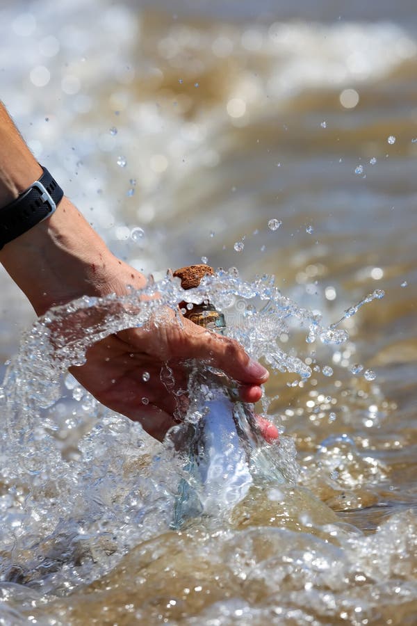 Hand Picking Up Glass Bottle with Message from Sea Stock Photo - Image ...
