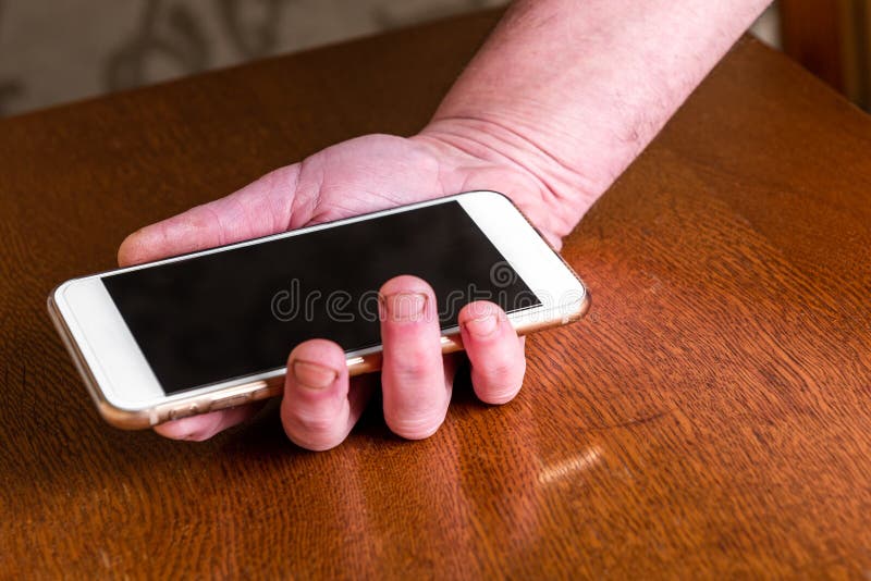 Hand Picking Up Mobile Phone from Table. Stock Photo - Image of display ...