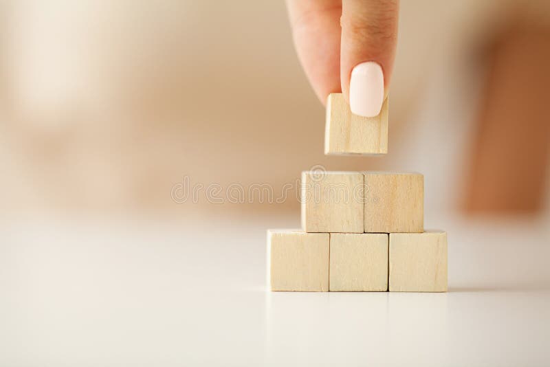 Hand Picking Up One Wooden Cube on Table Background. Stock Image ...