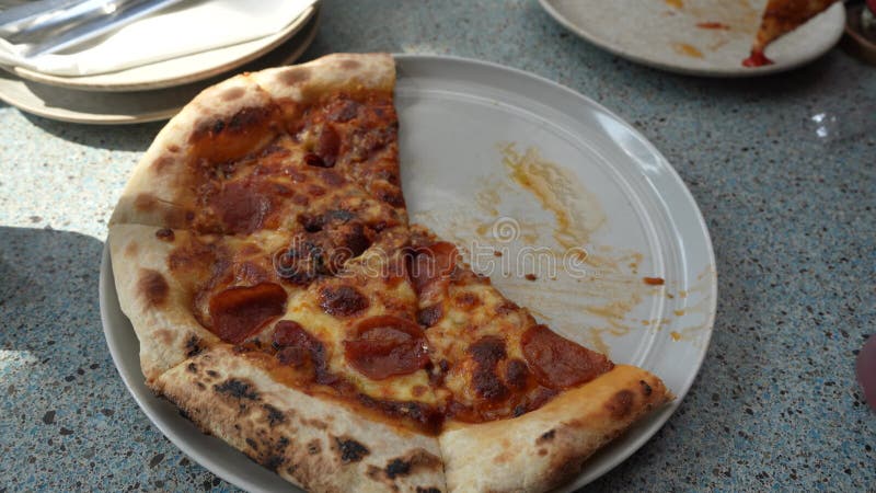 A Hand Picking Up the Sliced Pizza from a Plate on the Table Stock ...