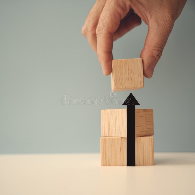 Hand Places Block Atop Stack with Arrow Pointing Up, Blue Background ...