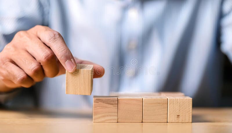 A Hand Places a Wooden Block Onto a Structure of Similar Blocks Stock ...