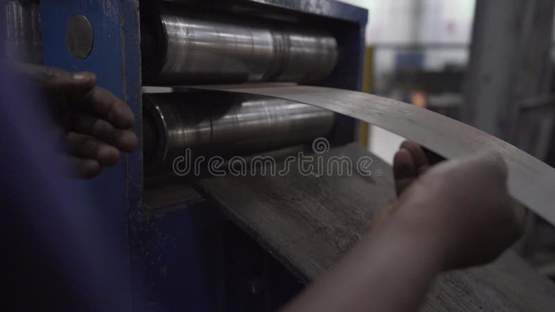 Hand Placing a Metallic Long Sheet between Rollers of a Machinery ...