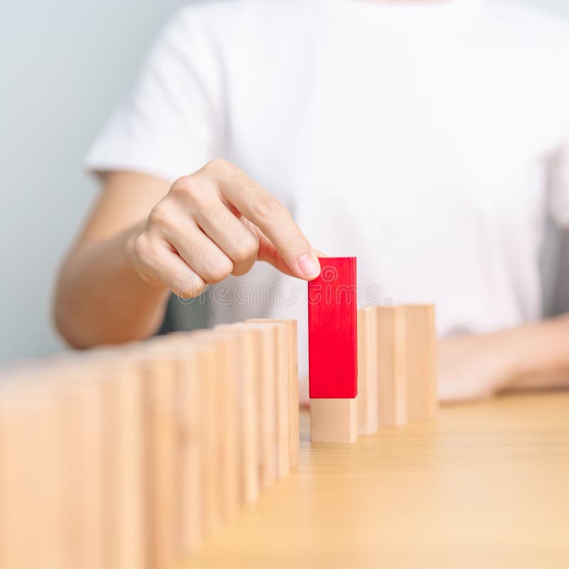 Hand Placing or Pulling Red Domino Wooden Block on Table. Business ...