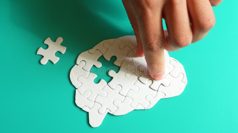 Hand Placing Puzzle Piece into Brain Shape on Teal Surface Stock ... Hand Placing Puzzle Piece into Brain Shape on Teal Surface Stock ...