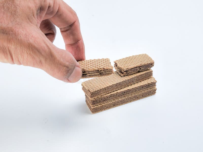Hand Placing Wafer Cookies on a Stack with a White Background Stock ...