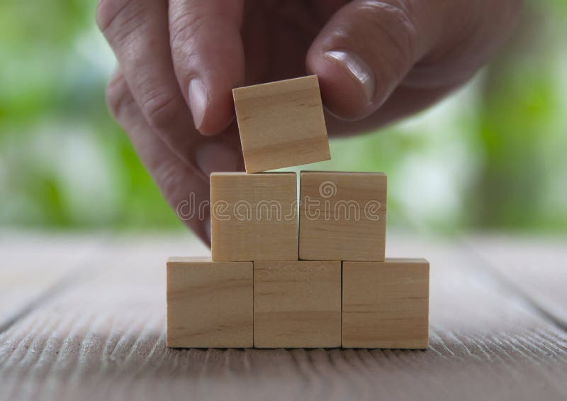 Hand Placing Wooden Cube on Top of Stacked Wooden Cube. Copy Space ...