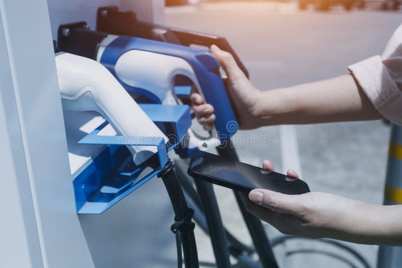 Hand Plugging in a Charger in an Electric Car Socket.Electric Car or Ev ...
