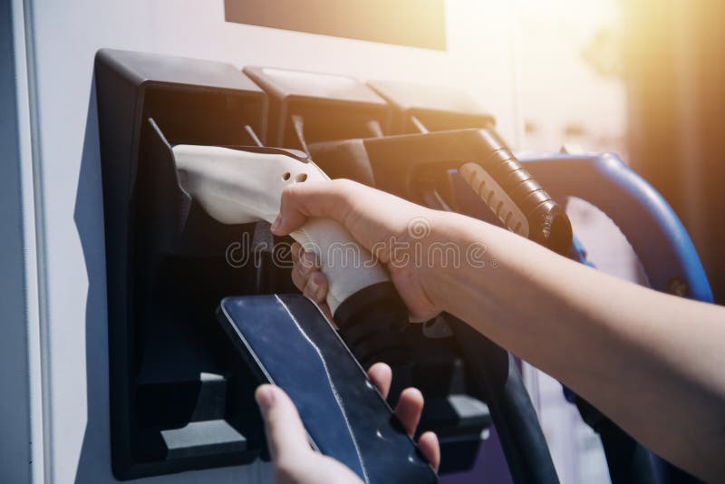 Hand Plugging in a Charger in an Electric Car Socket.Electric Car or Ev ...