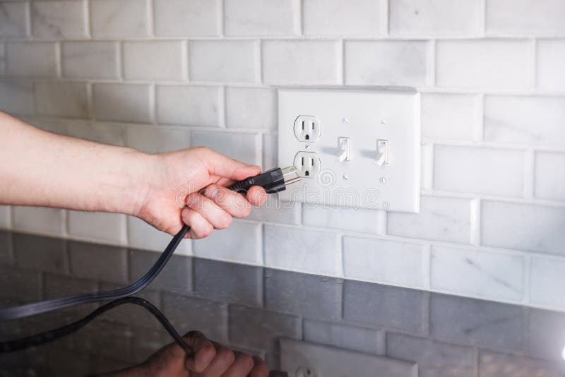 Hand Plugging in Electrical Cord into Home Outlet Stock Photo - Image ...