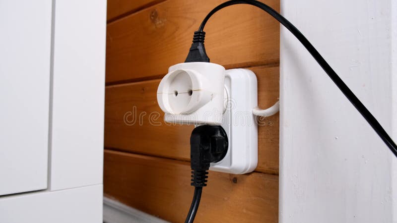 Overloaded Outlet with an Extension and Many Sockets Plugged in, a Hand ...