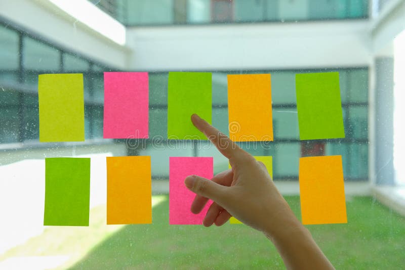 Hand Pointing at Adhesive Notes on Glass Wall. Sticky Note Paper Stock ...