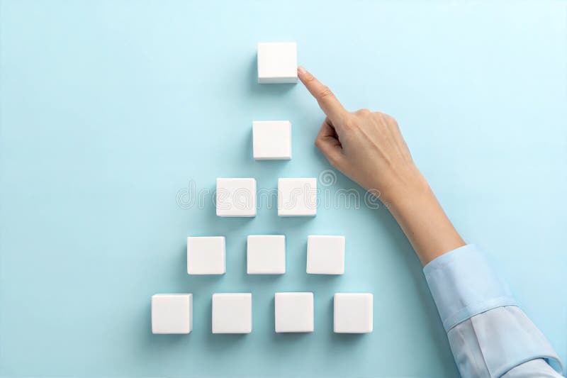 Hand Pointing To the Top of a Pyramid of White Blocks on a Light Blue ...