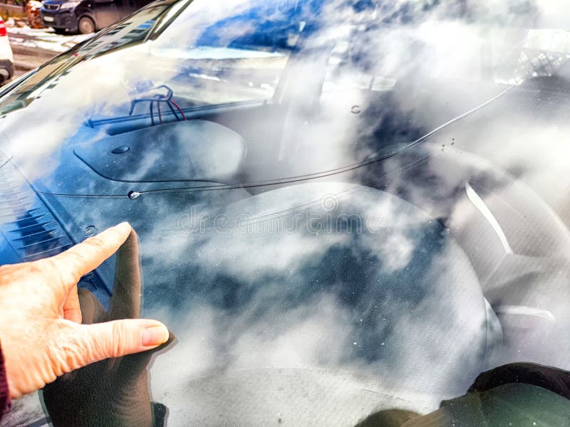A Hand Points at a Small Chip and Crack on a Car Windshield Stock Photo ...