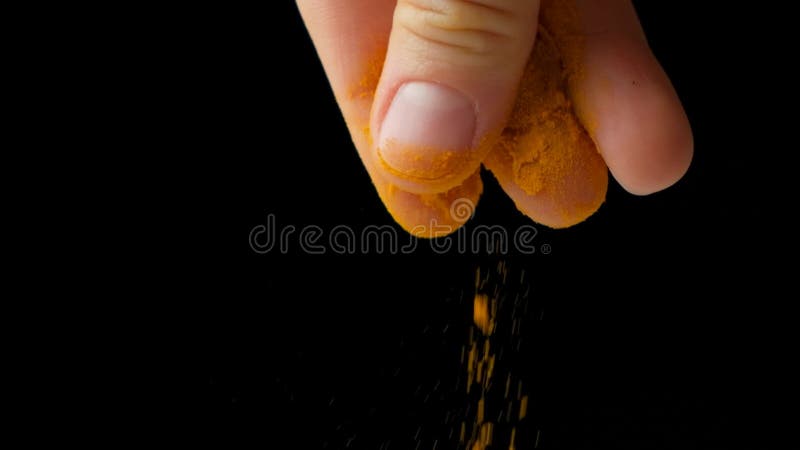 Hand Pouring Turmeric Powder on Black Background, Slow Motion. Stock ...