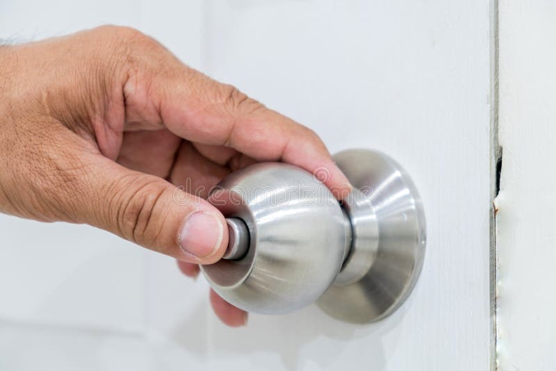 Hand Pressing Door Knob Mounted on a White Wooden Door. Stock Photo ...