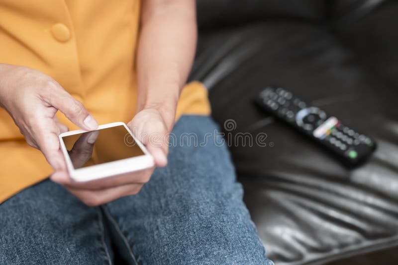 The Hand is Pressing the Phone and Remote Control To Select the Channel ...