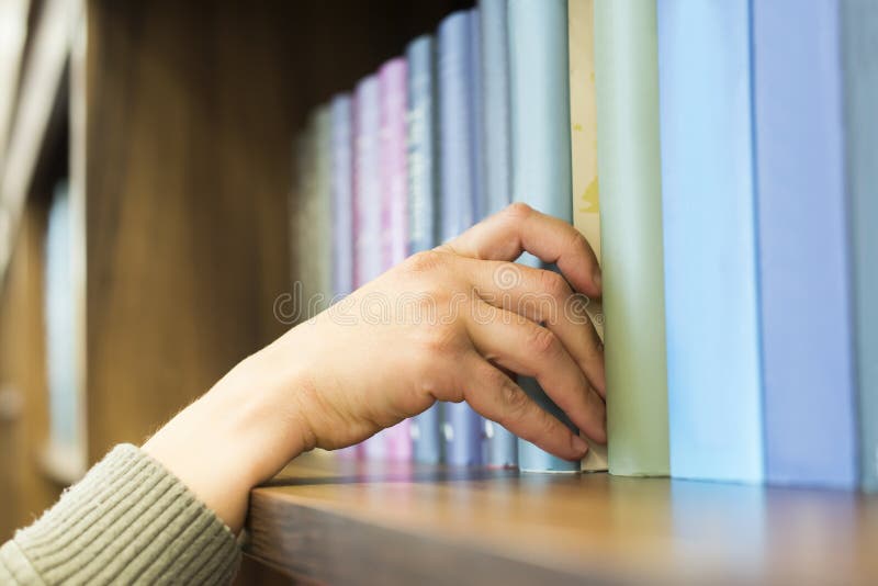 Hand Pulling a Book Off the Shelf Stock Photo - Image of pulling, human ...