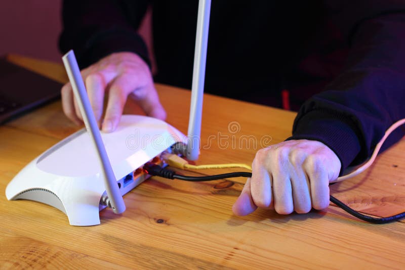 Hand Pulling Internet Cable from White Router with Antennas Stock Photo ...