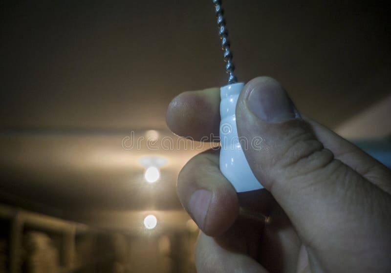 Hand Pulling a Light Porcelain Chain Light Switch Attached To the ...