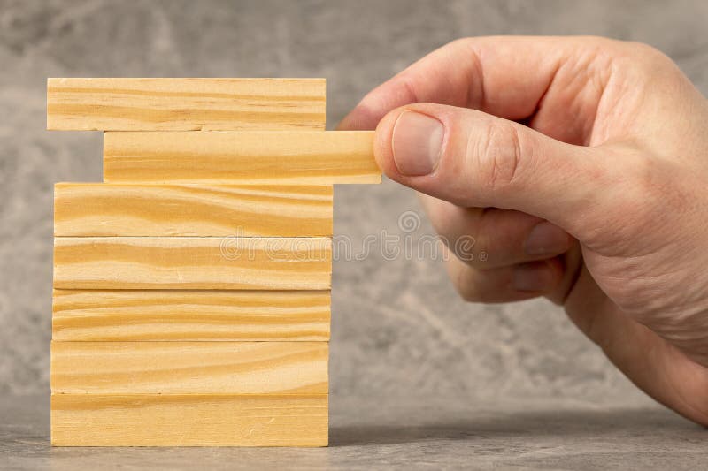 Hand Pulling Out Wooden Block from a Tower Stock Image - Image of ...