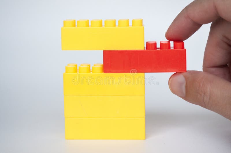 Hand Pulling Red Lego from the Rest. Building Concept Stock Photo ...